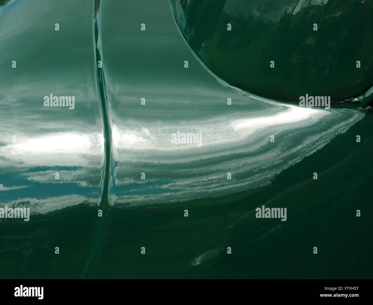 Reflections in curved surface of shiny green paintwork of a classic car ...