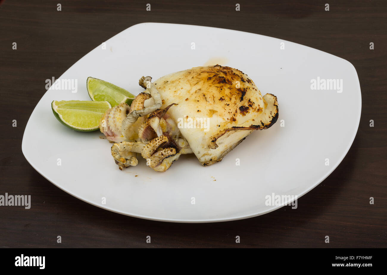 Grilled cuttlefish with lime on the wooden background Stock Photo - Alamy