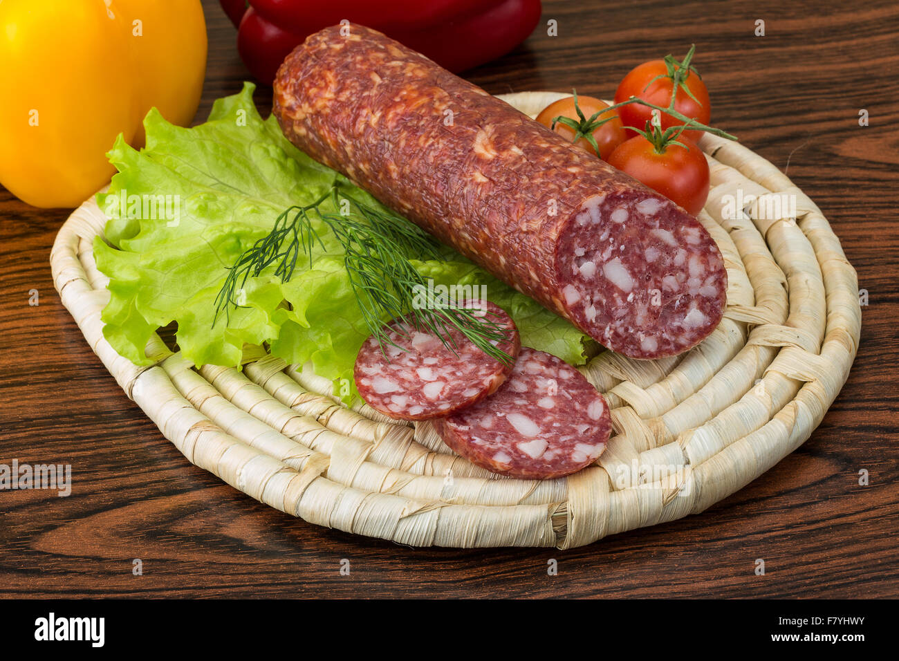 Sliced Salami with salad leaves on the wood background Stock Photo - Alamy