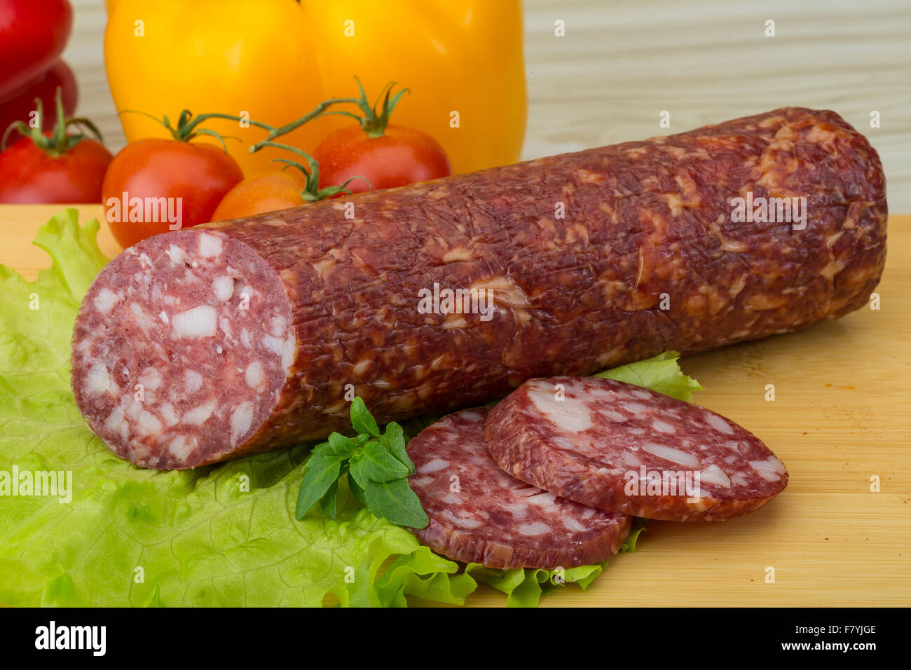 Sliced Salami with salad leaves on the wood background Stock Photo - Alamy