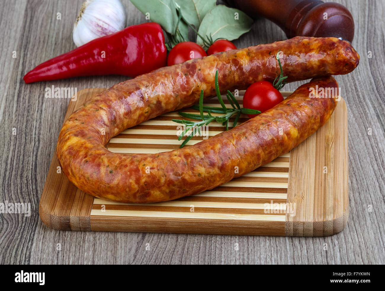 Sausage ring with rosemary and pepper on the wood background Stock ...