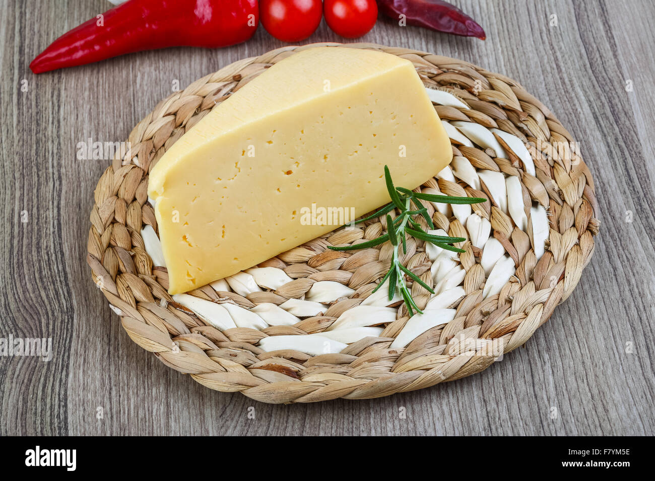 Yellow young cheese with pepper, rosemary and tomatoes Stock Photo - Alamy
