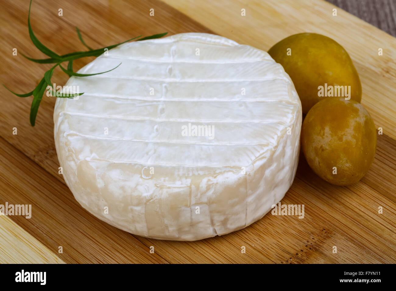 Round Brie cheese with yellow plums and estragon Stock Photo - Alamy