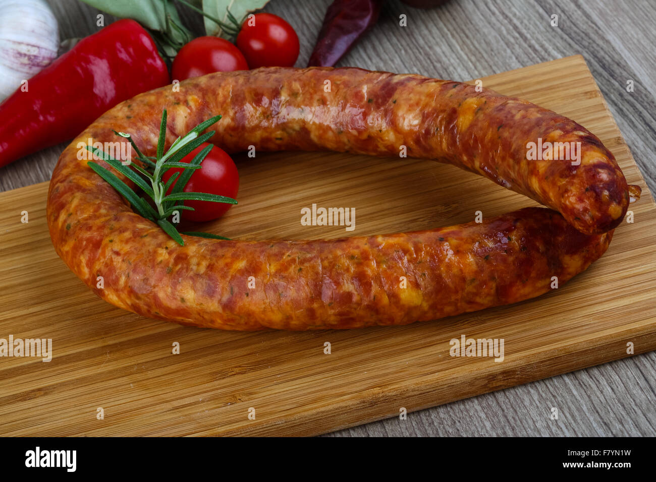 Sausage ring with rosemary and pepper on the wood background Stock ...