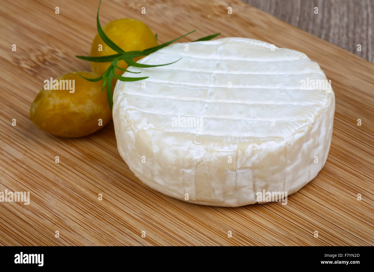 Round Brie cheese with yellow plums and estragon Stock Photo - Alamy