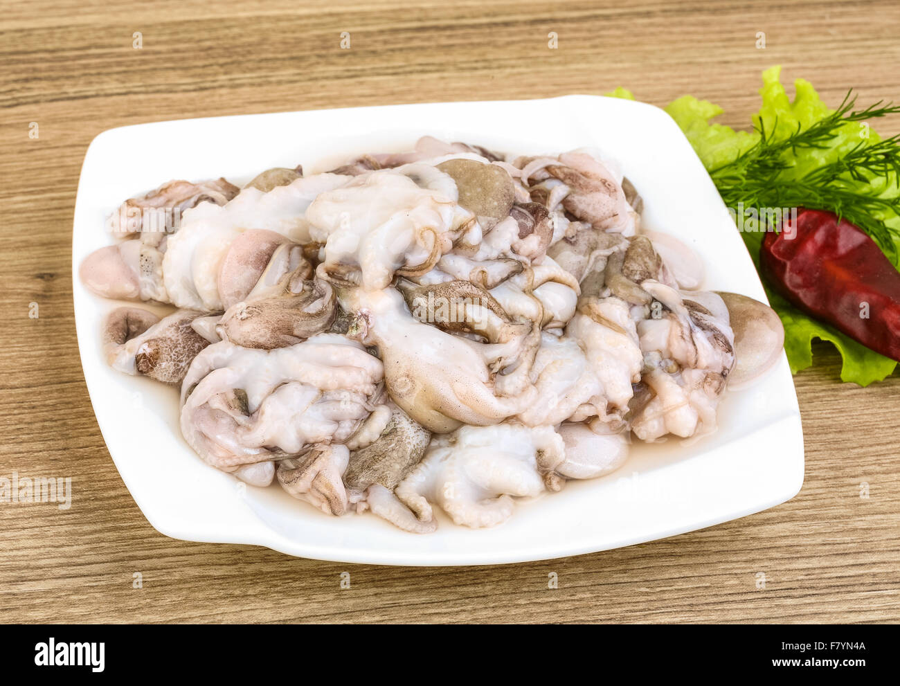 Raw baby octopus in the bowl ready for cooking Stock Photo - Alamy