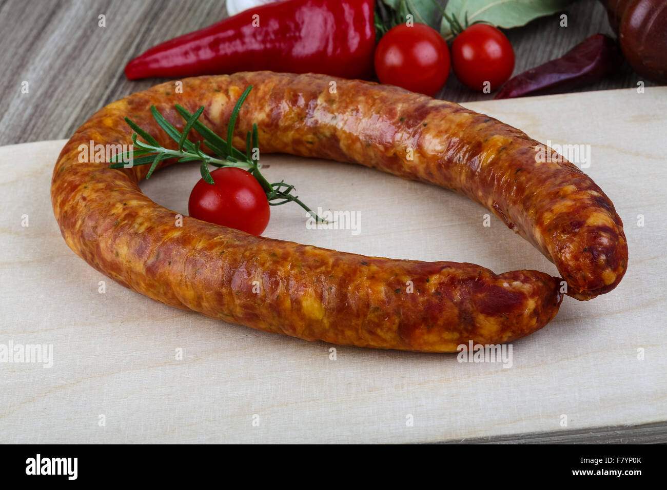 Sausage ring with rosemary and pepper on the wood background Stock ...