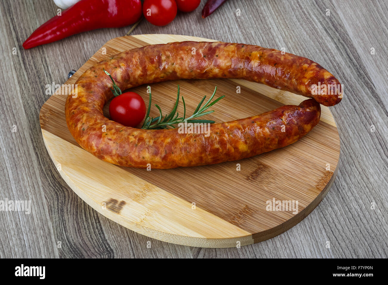Sausage ring with rosemary and pepper on the wood background Stock ...
