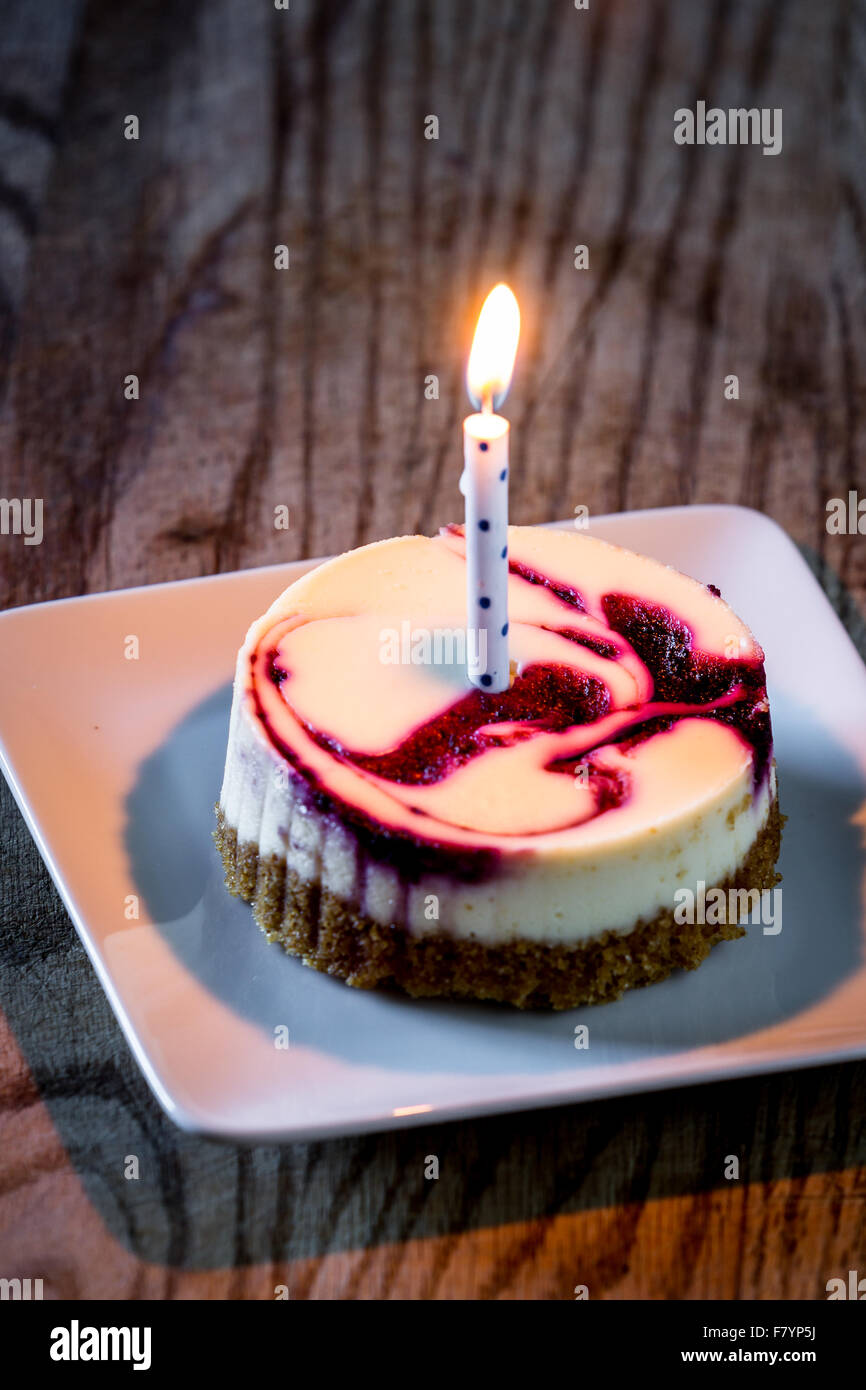 individual serving of huckleberry cheesecake with a birthday candle ...