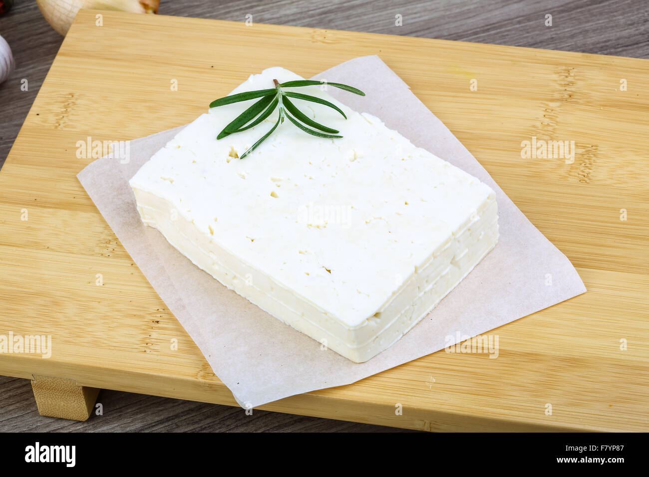 White bulgarian cheese brinza with rosemary on the wood background ...
