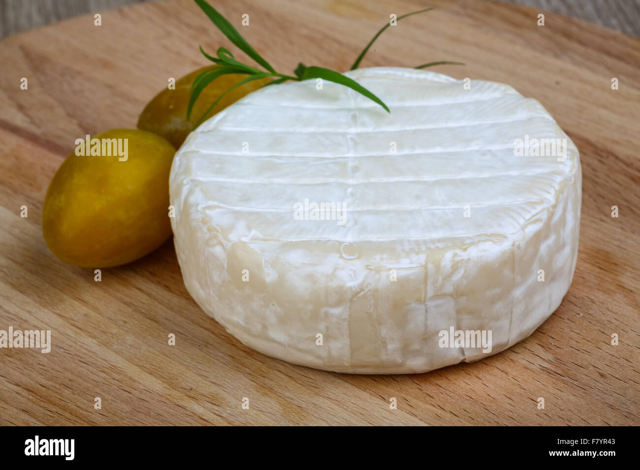 Round Brie cheese with yellow plums and estragon Stock Photo - Alamy