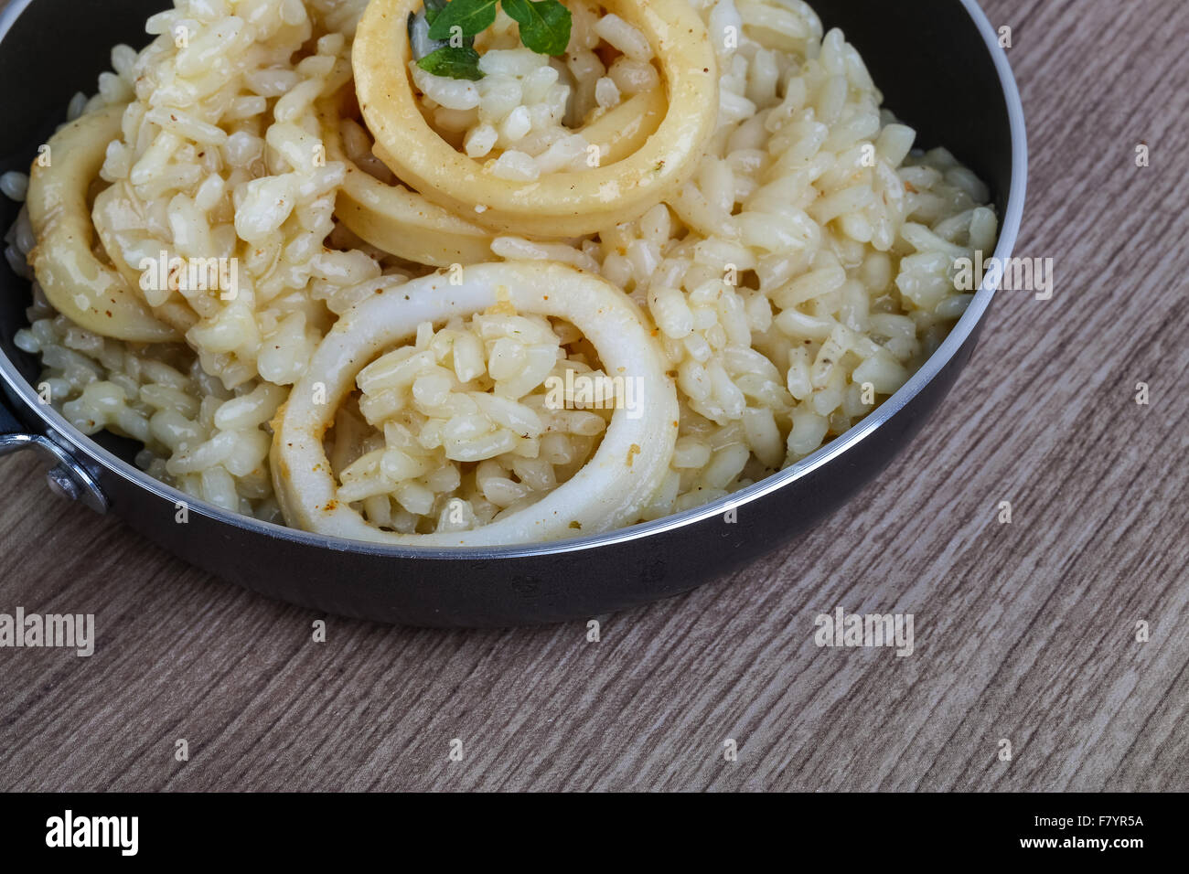 Italian famous cuisine - Squid risotto served basil leaves Stock Photo ...