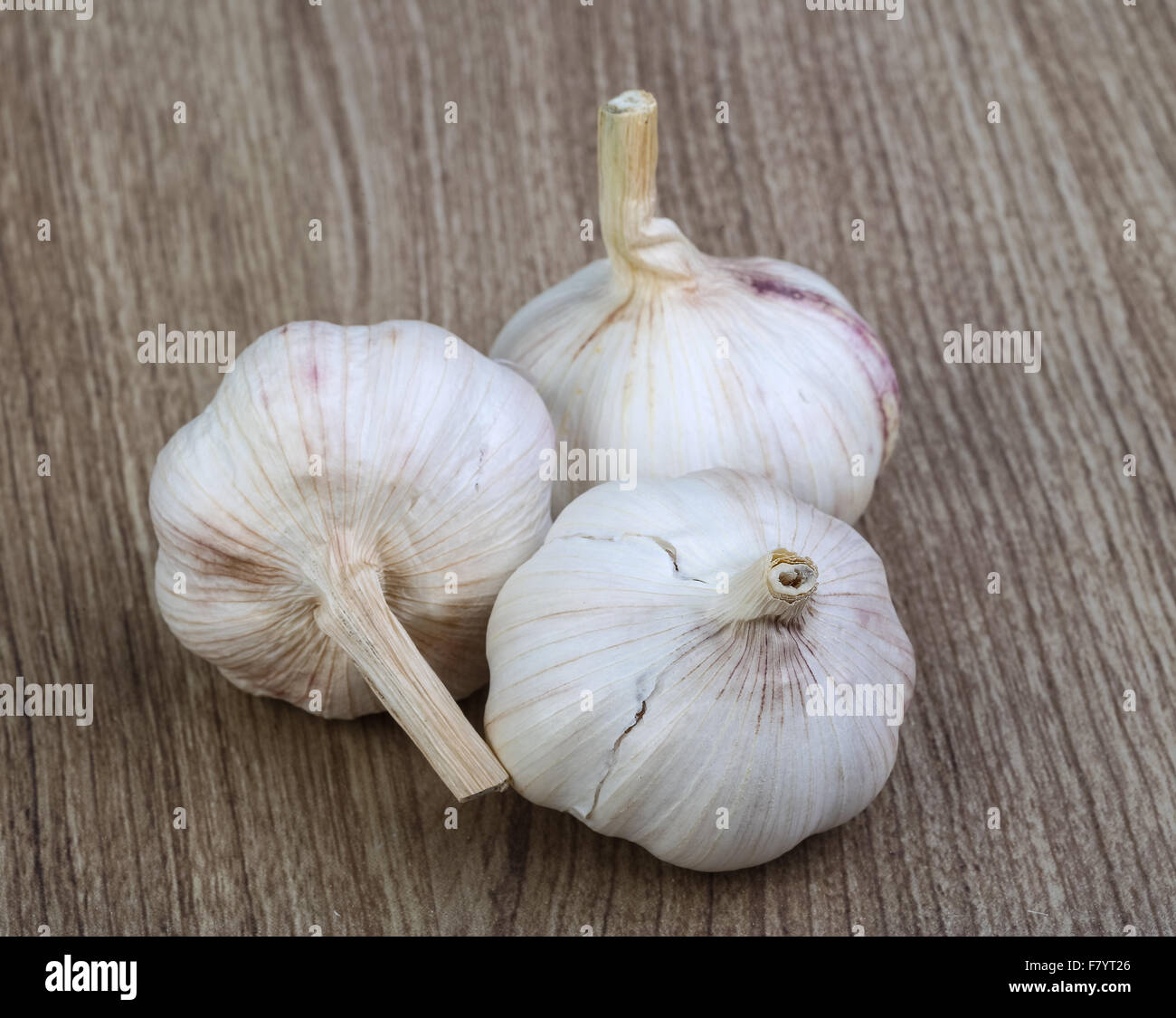 Fresh ripe garlic heaps - on wood background Stock Photo - Alamy