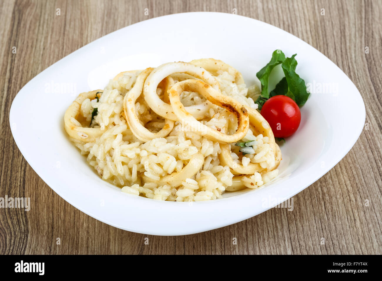 Italian famous cuisine - Squid risotto served basil leaves Stock Photo ...