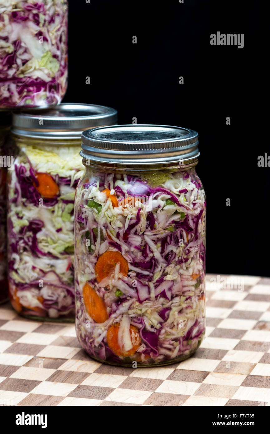 home made cultured or fermented vegetables in a jar over a dark ...