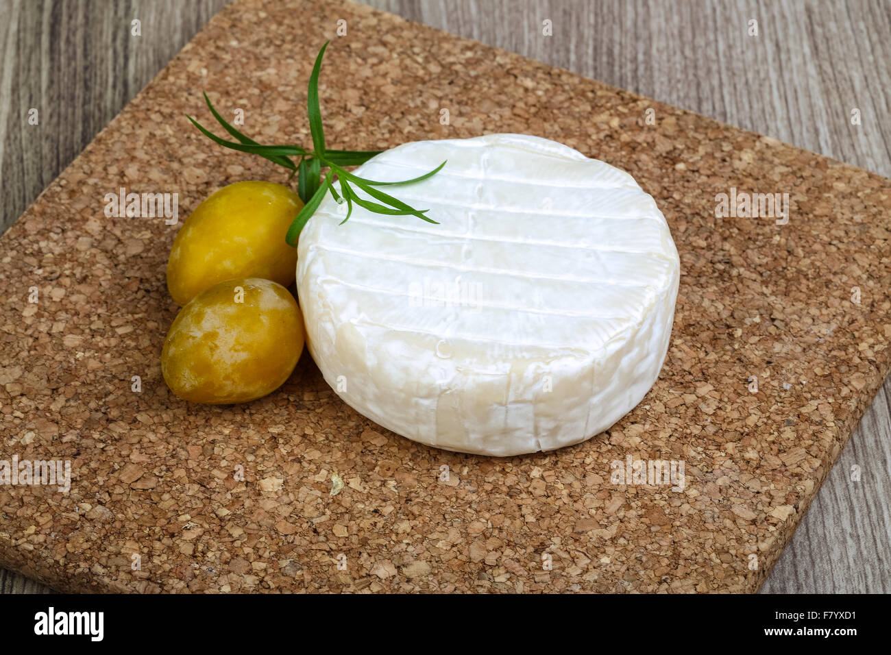 Round Brie cheese with yellow plums and estragon Stock Photo - Alamy