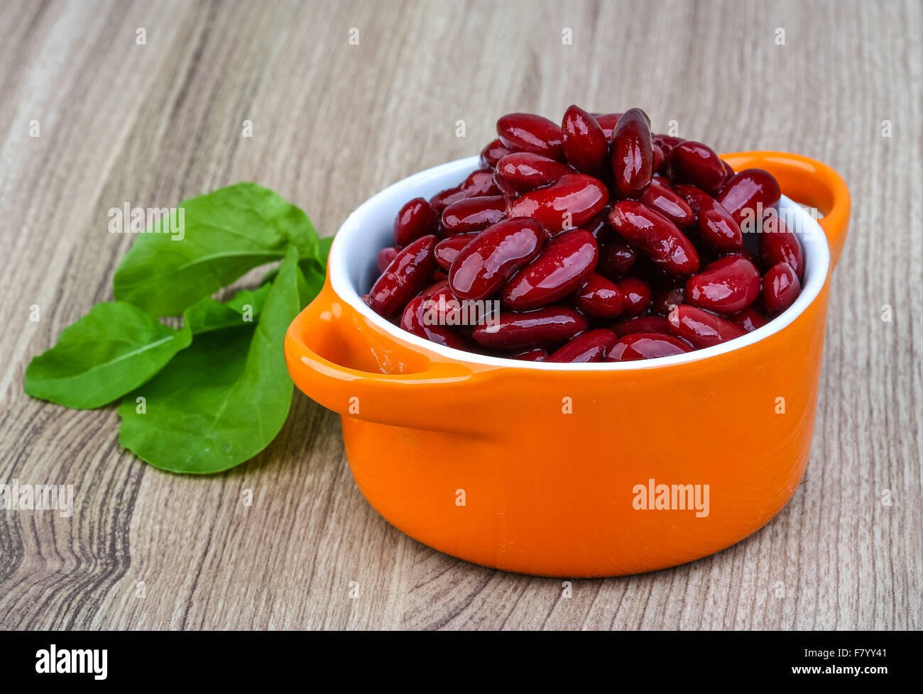 Red kidney on the bowl with ruccola leaves wood background Stock Photo ...