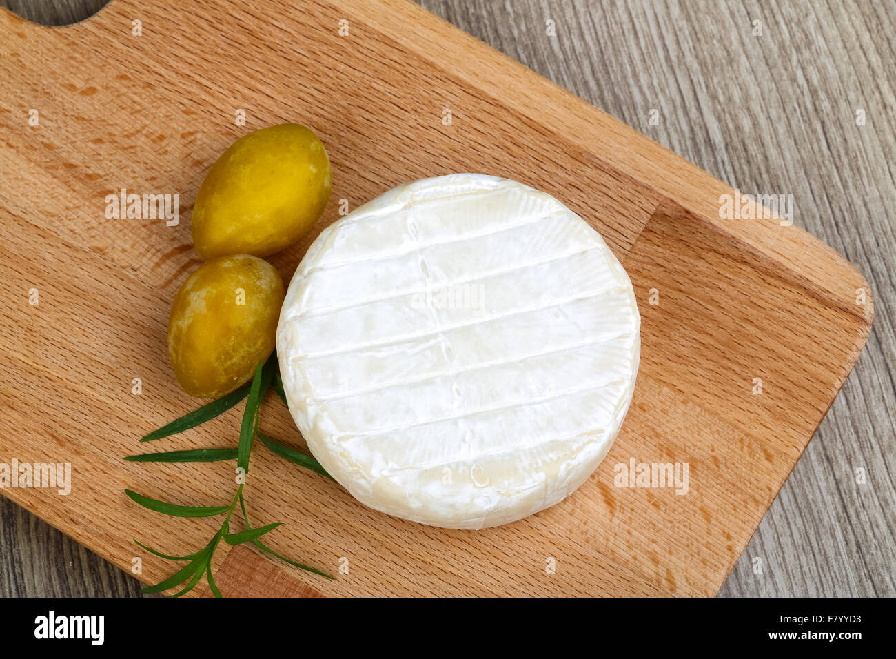 Round Brie cheese with yellow plums and estragon Stock Photo - Alamy