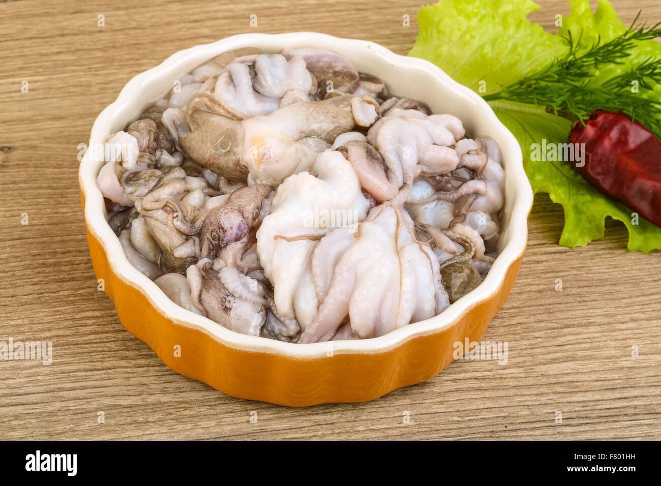Raw baby octopus in the bowl ready for cooking Stock Photo - Alamy