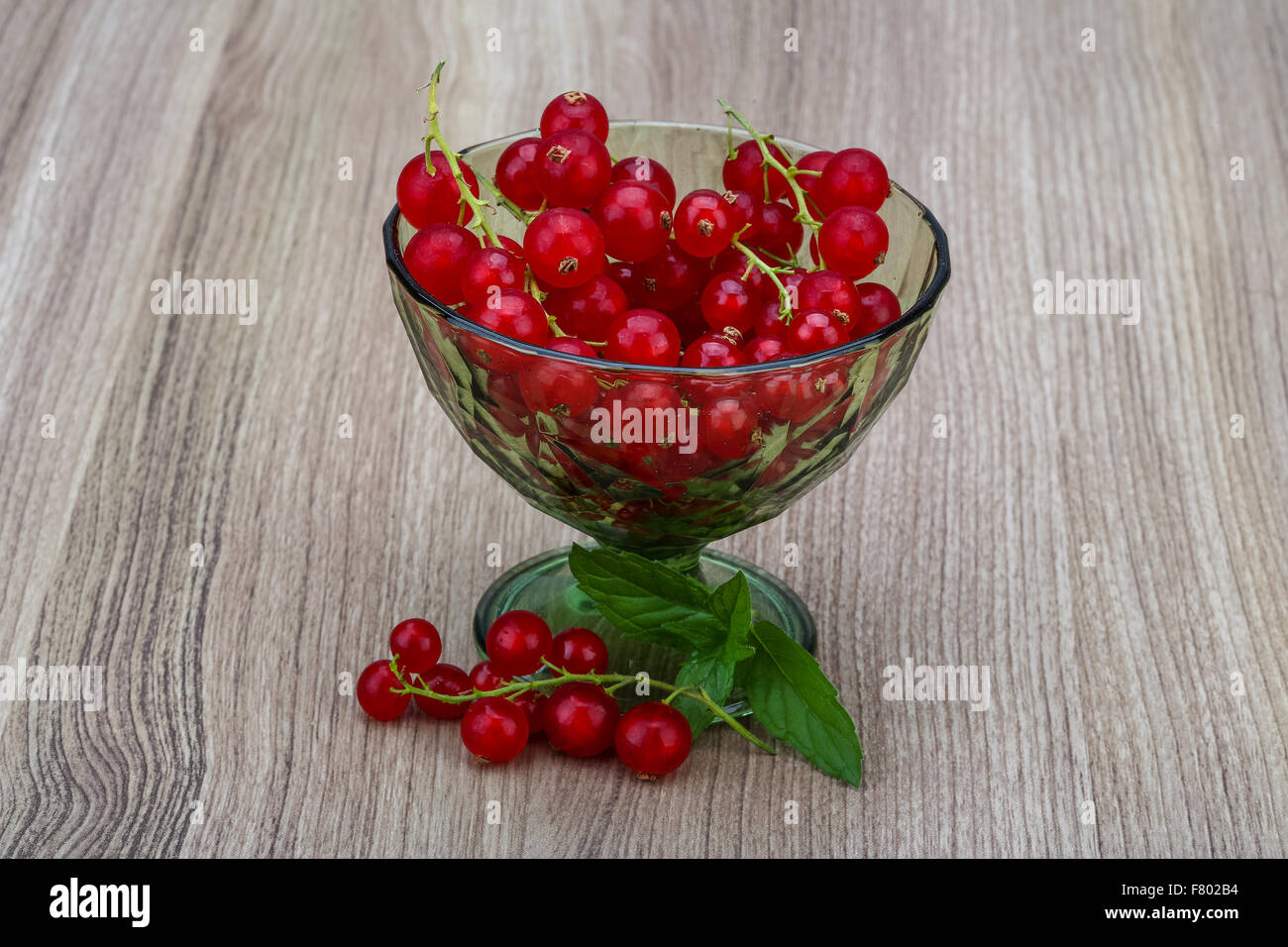 Fresh bright Red currant on the wood background with mint leaves Stock ...