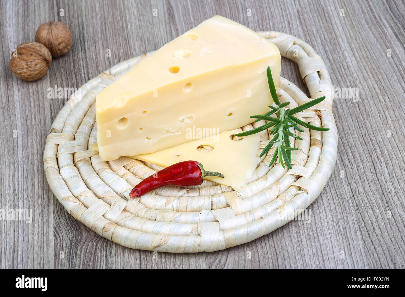 Yellow young cheese with pepper, rosemary and walnuts Stock Photo - Alamy