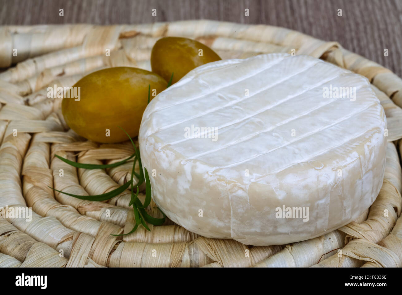 Round Brie cheese with yellow plums and estragon Stock Photo - Alamy