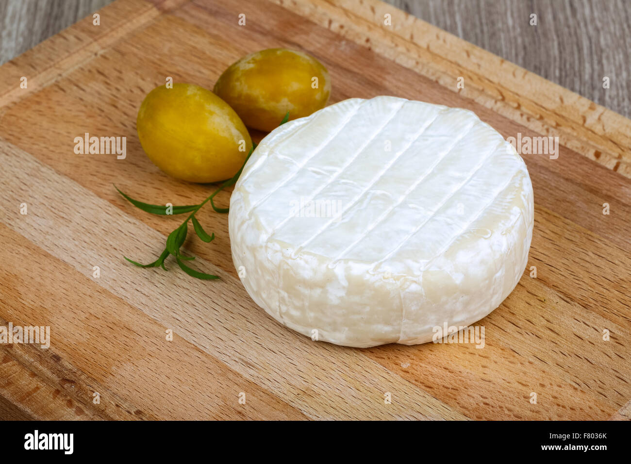 Round Brie cheese with yellow plums and estragon Stock Photo - Alamy