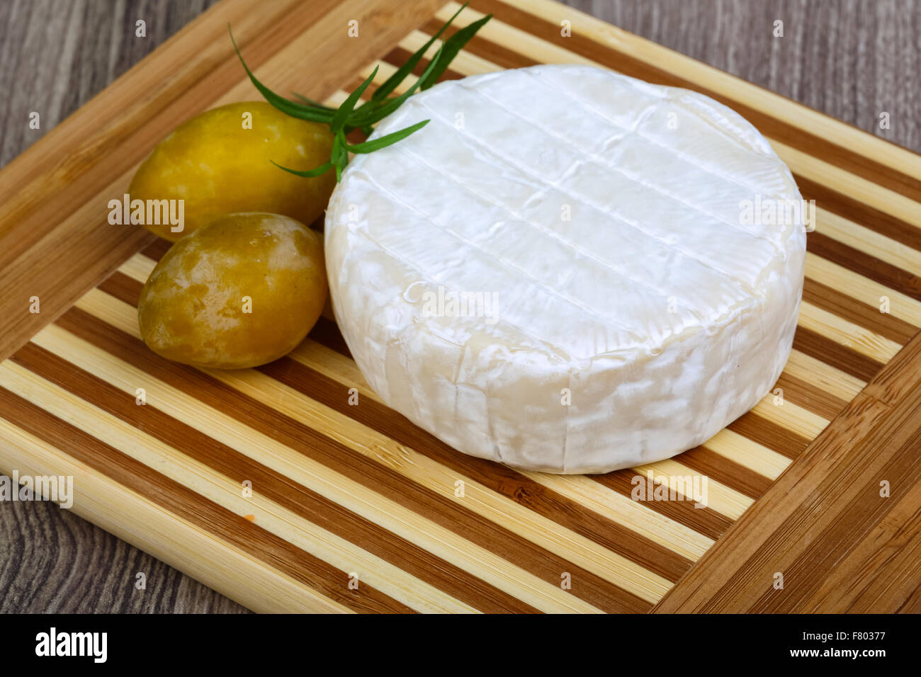 Round Brie cheese with yellow plums and estragon Stock Photo - Alamy