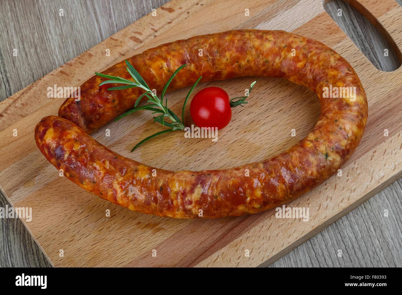 Sausage ring with rosemary and pepper on the wood background Stock ...