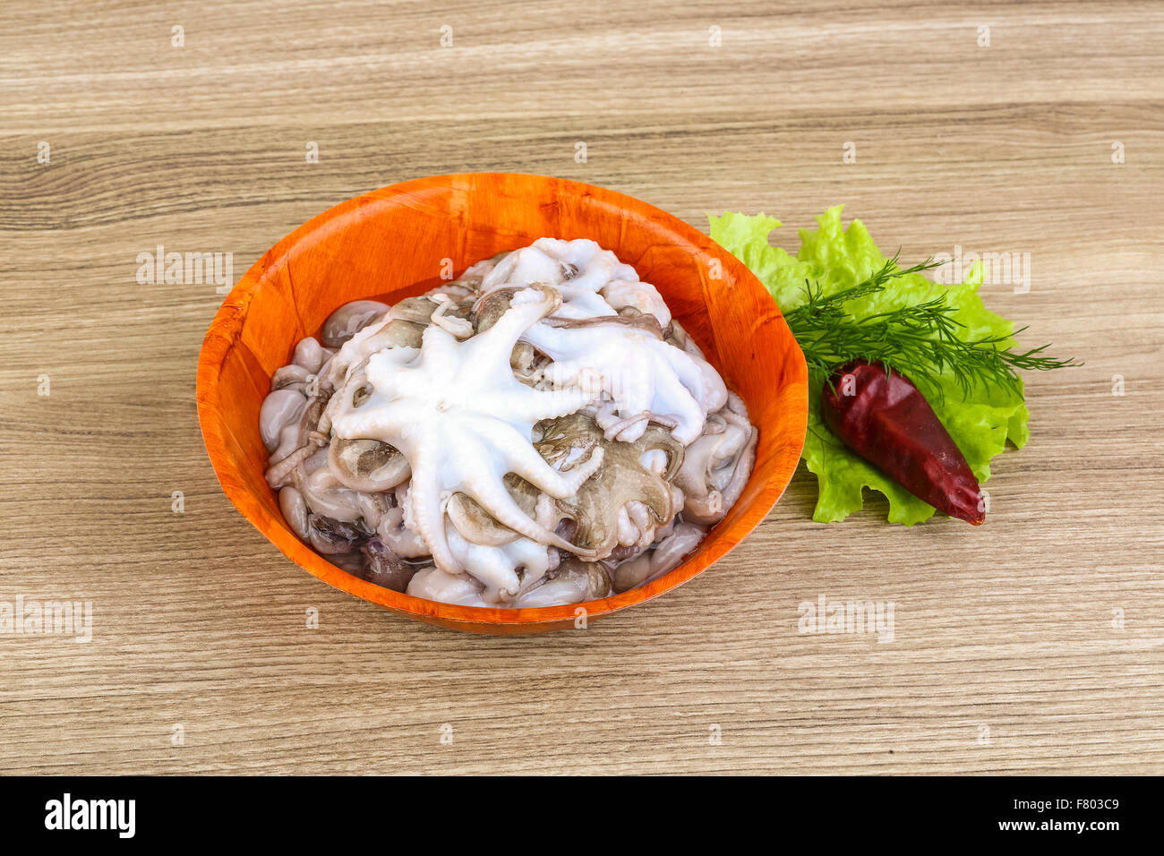 Raw baby octopus in the bowl ready for cooking Stock Photo - Alamy