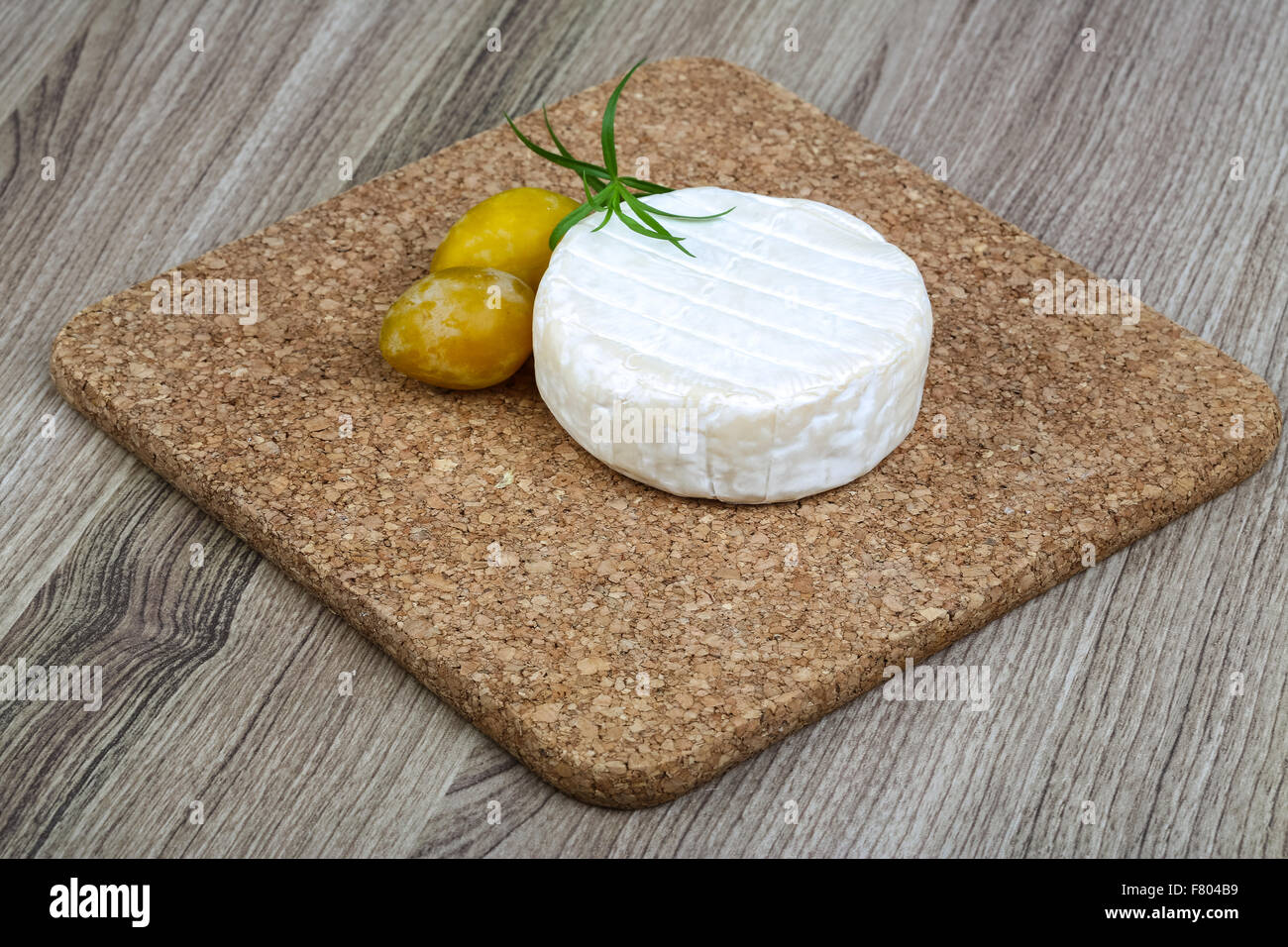 Round Brie cheese with yellow plums and estragon Stock Photo - Alamy