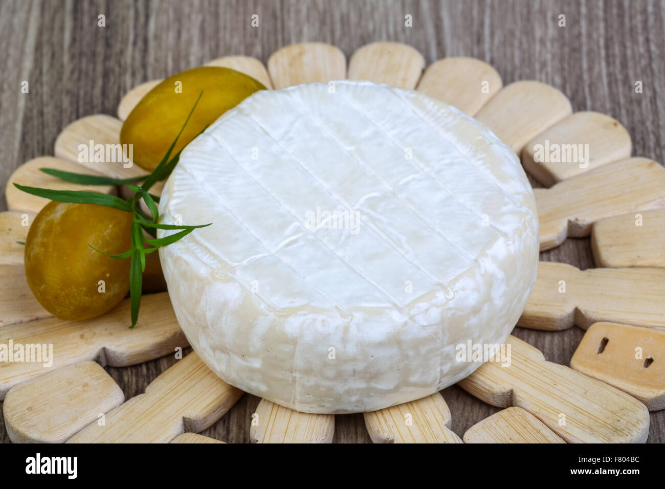 Round Brie cheese with yellow plums and estragon Stock Photo - Alamy