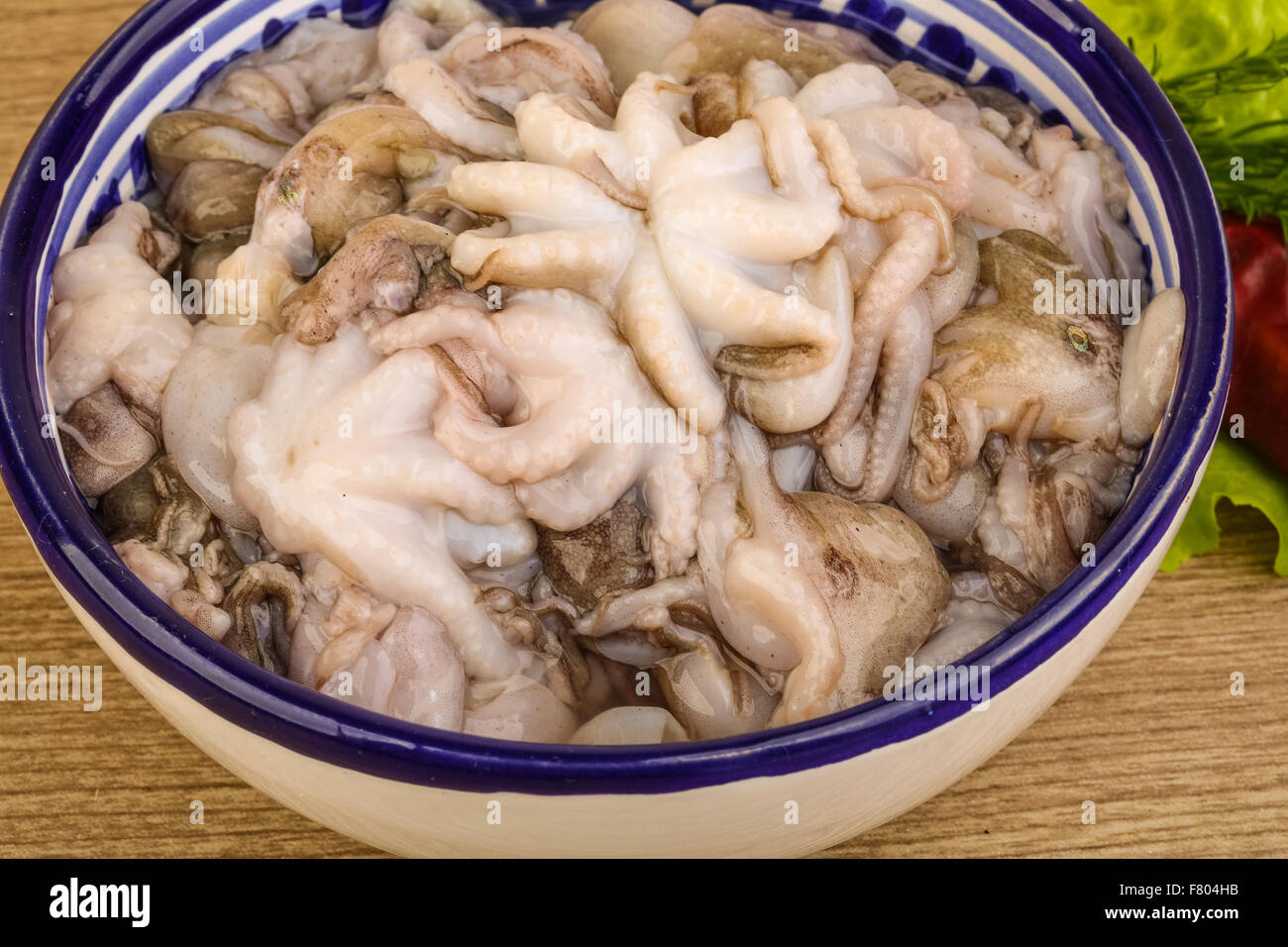 Raw baby octopus in the bowl ready for cooking Stock Photo - Alamy