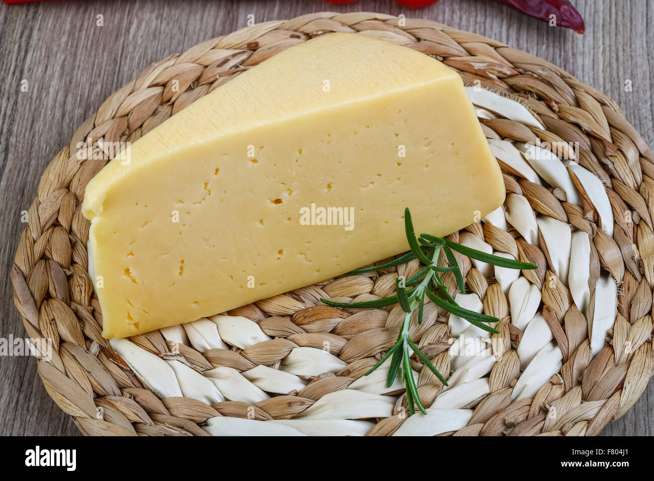 Yellow young cheese with pepper, rosemary and tomatoes Stock Photo - Alamy