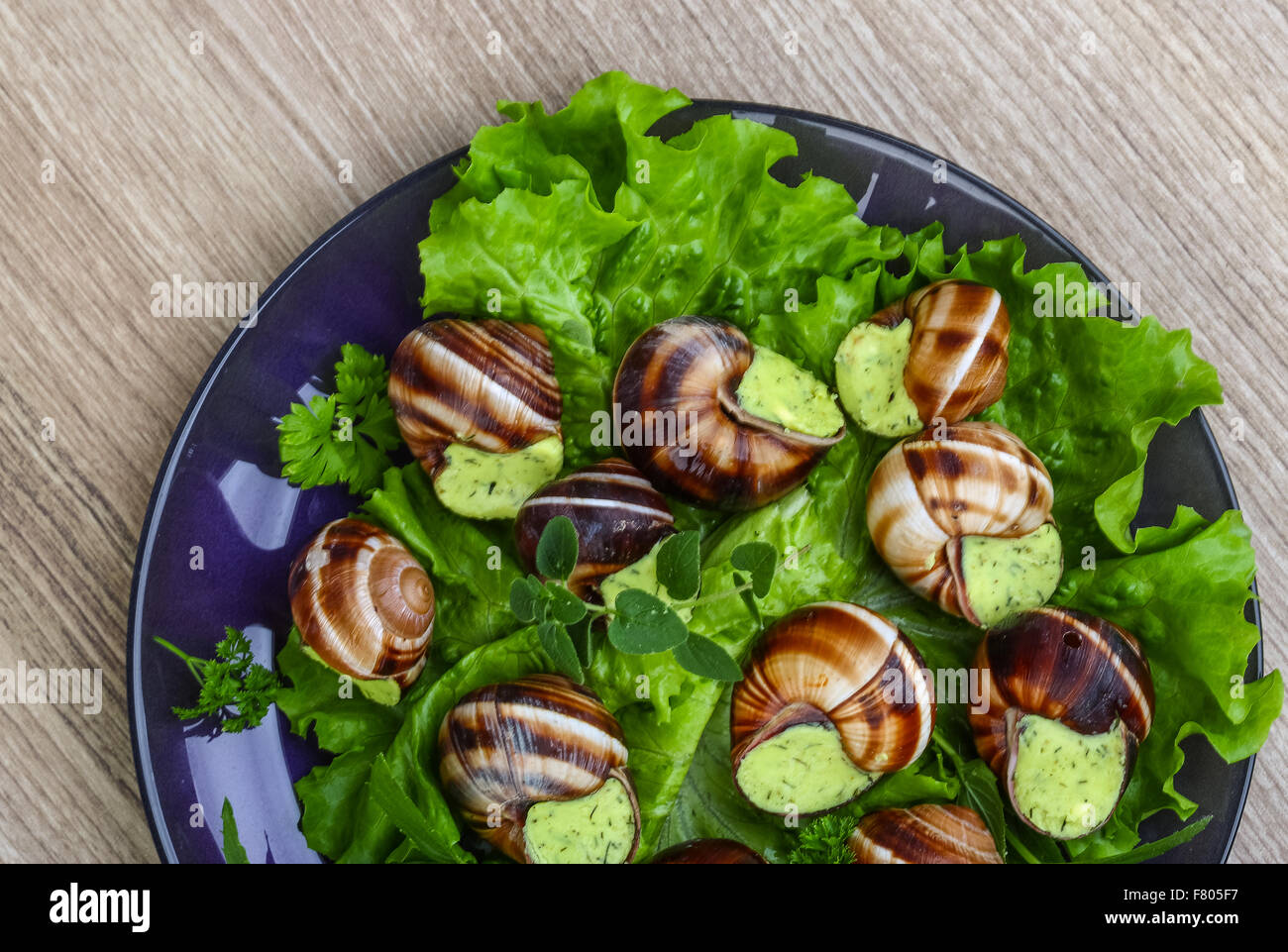 French cuisine - Escargot with butter, parsley and salat leaves Stock ...