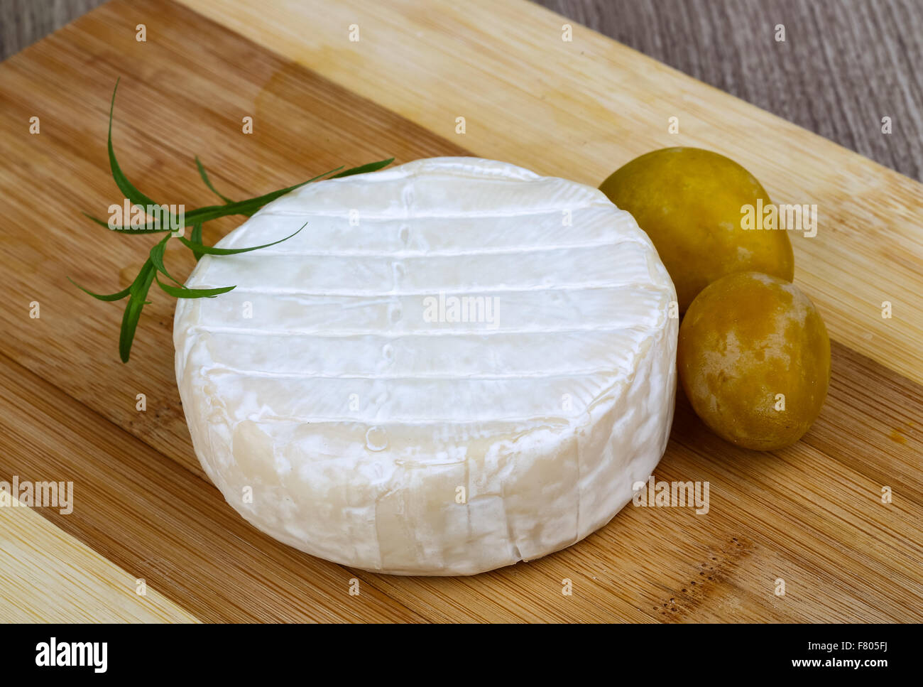 Round Brie cheese with yellow plums and estragon Stock Photo - Alamy
