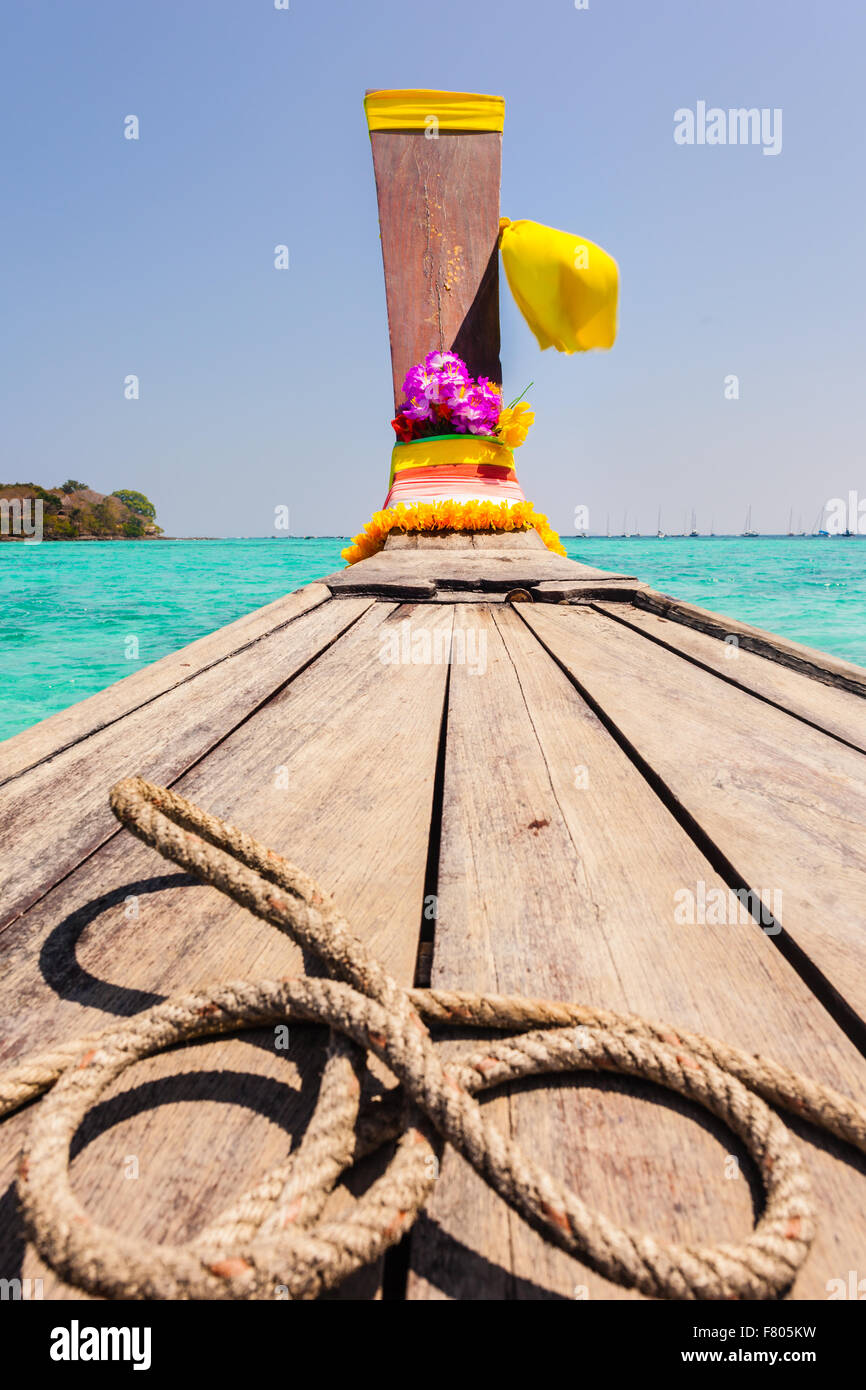 The bow of a traditional thai long tail boat decorated with ribbons and ...