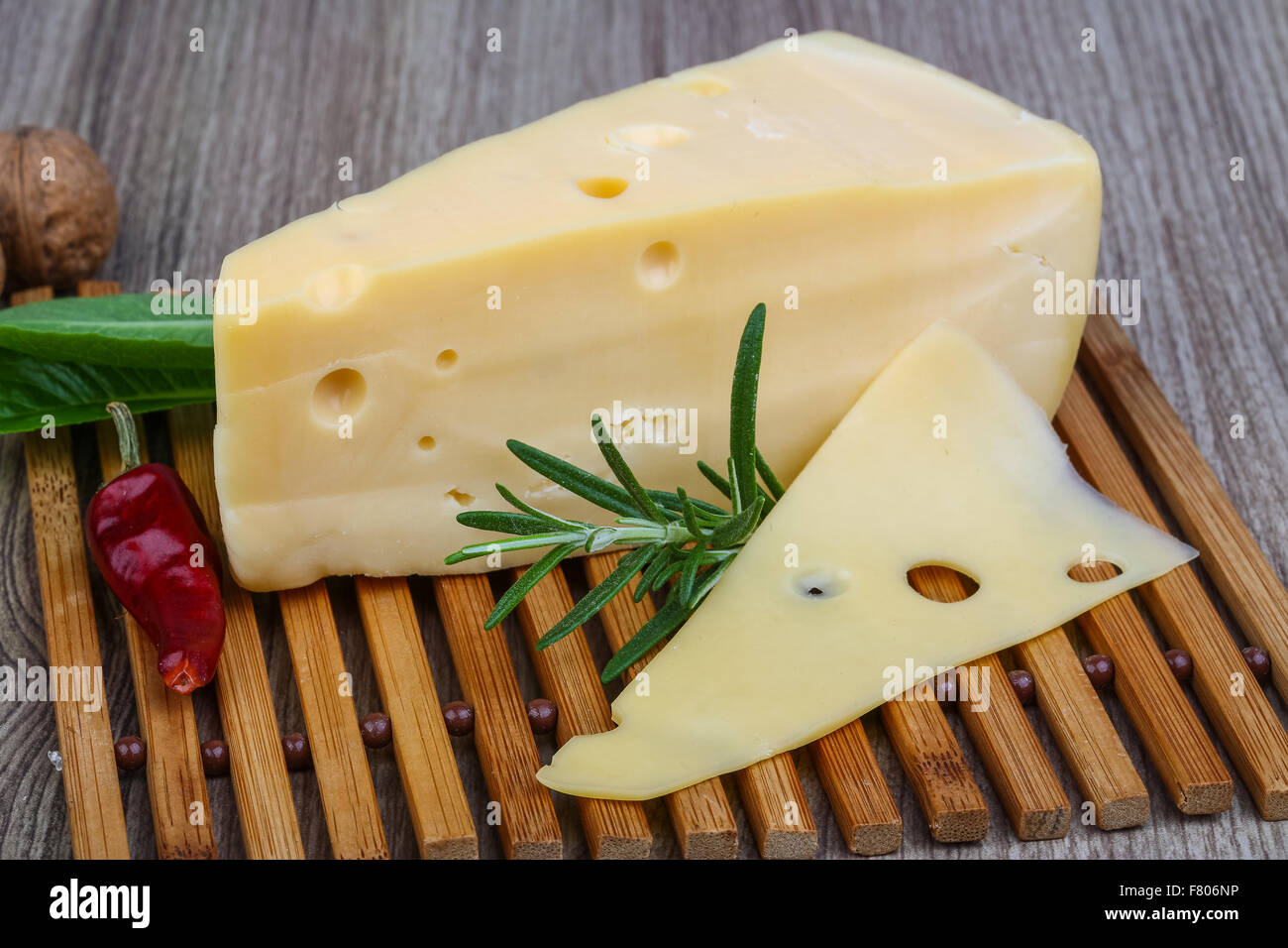 Triangle yellow cheese with rosemary, pepper and salad leaves Stock ...