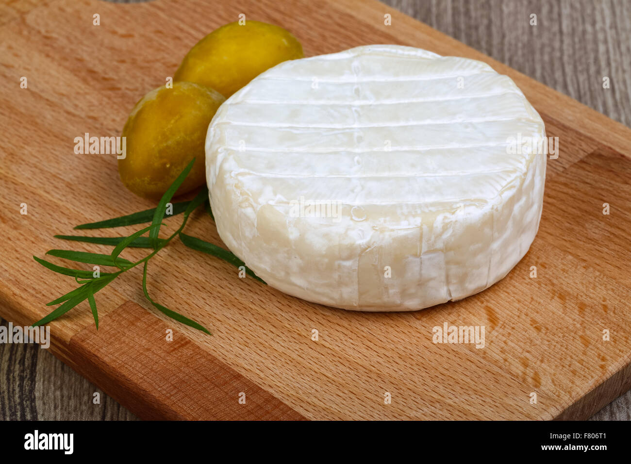 Round Brie cheese with yellow plums and estragon Stock Photo - Alamy
