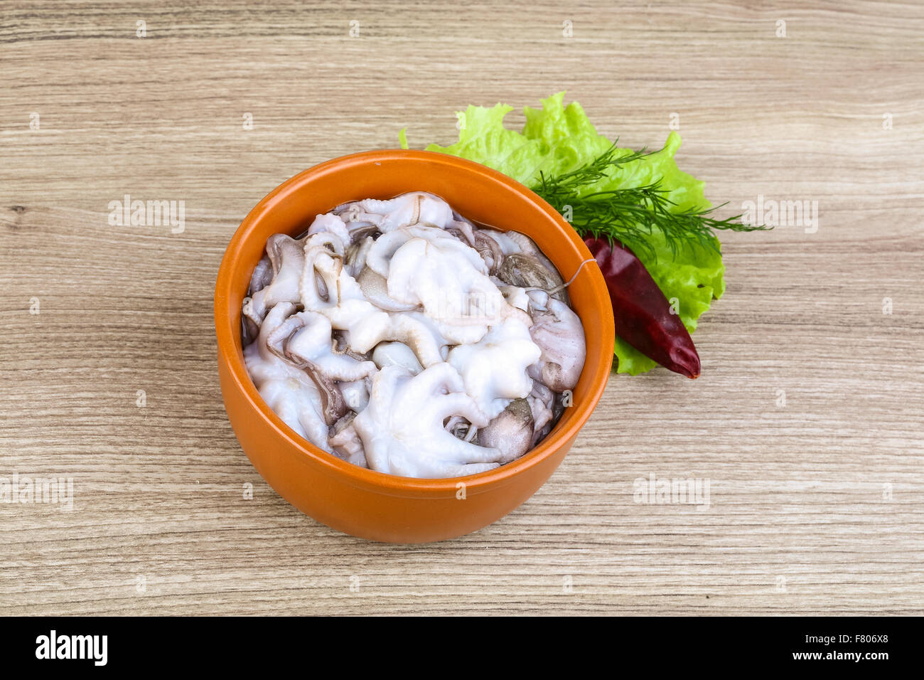 Raw baby octopus in the bowl ready for cooking Stock Photo - Alamy