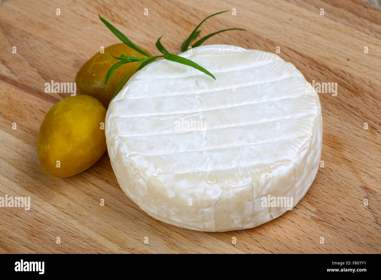 Round Brie cheese with yellow plums and estragon Stock Photo - Alamy