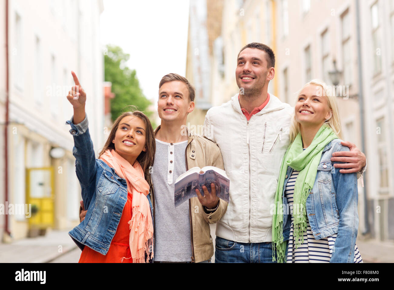 group of friends with city guide exploring town Stock Photo - Alamy