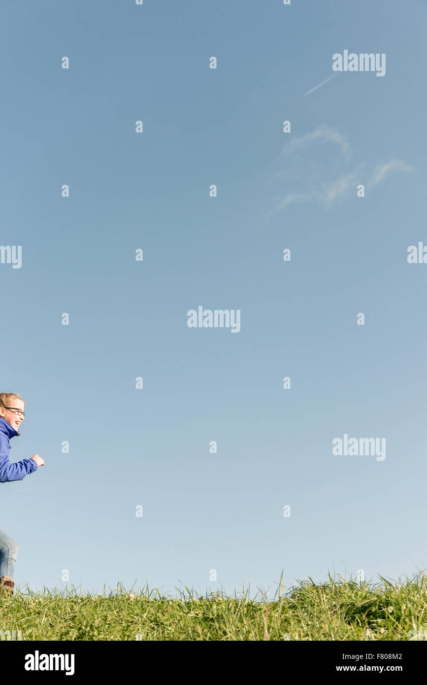 Girl running in front of blue sky Stock Photo - Alamy