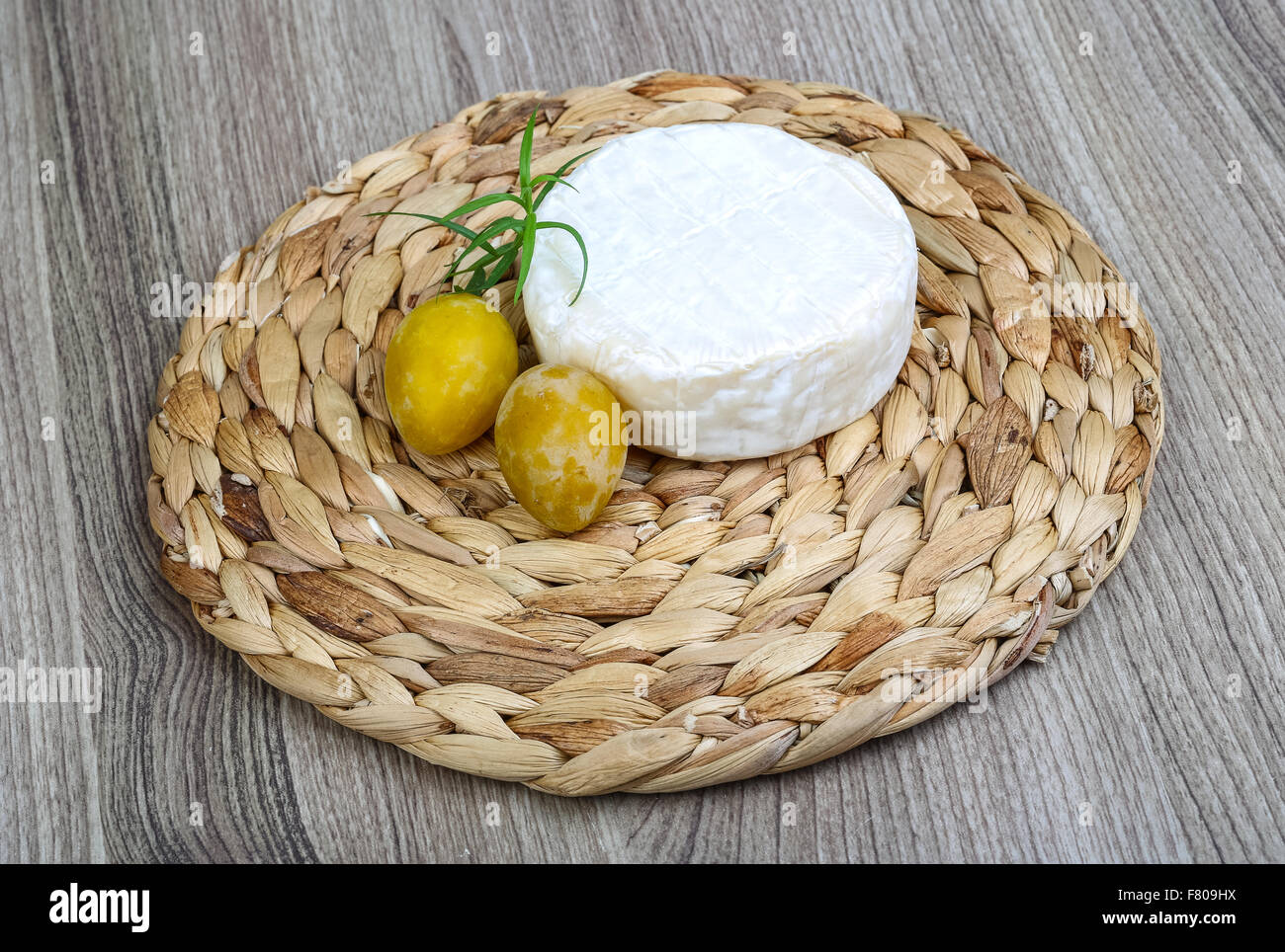 Brie cheese with yellow plums and estragon leaves Stock Photo - Alamy