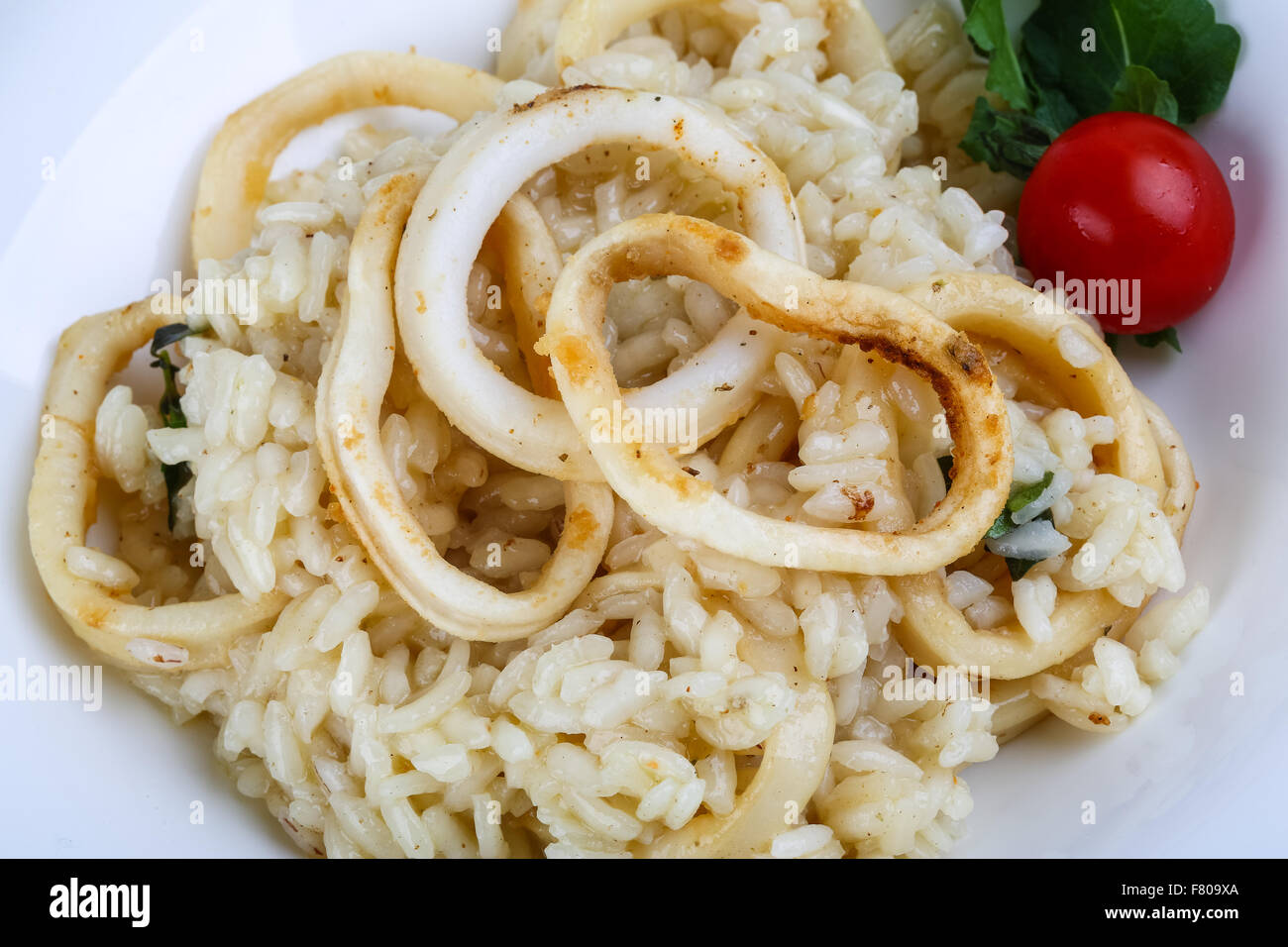 Italian famous cuisine - Squid risotto served basil leaves Stock Photo ...