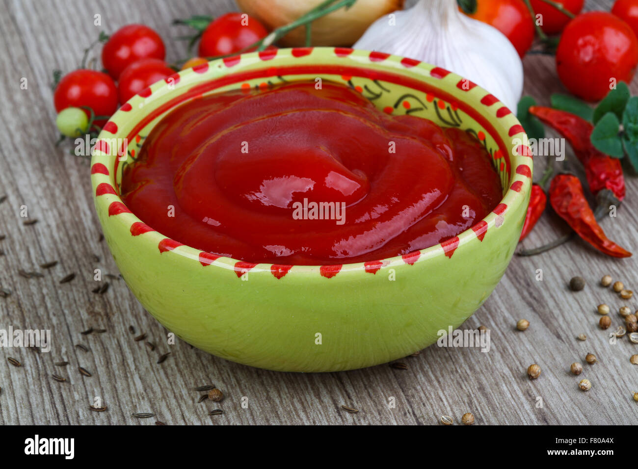 Bright Tomato ketchup with herbs and spices on the wood background ...