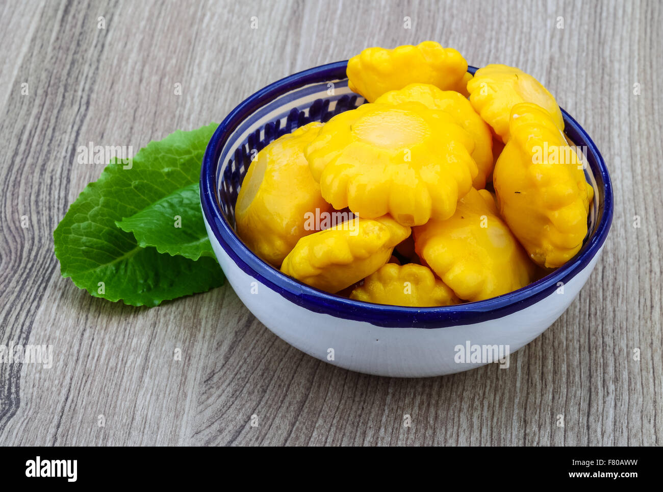 Pickled yellow patissons with salad leaves and fresh tomato Stock Photo ...