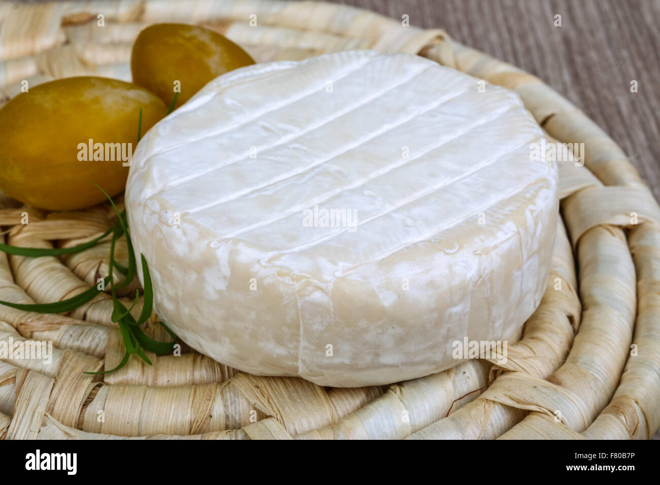 Round Brie cheese with yellow plums and estragon Stock Photo - Alamy