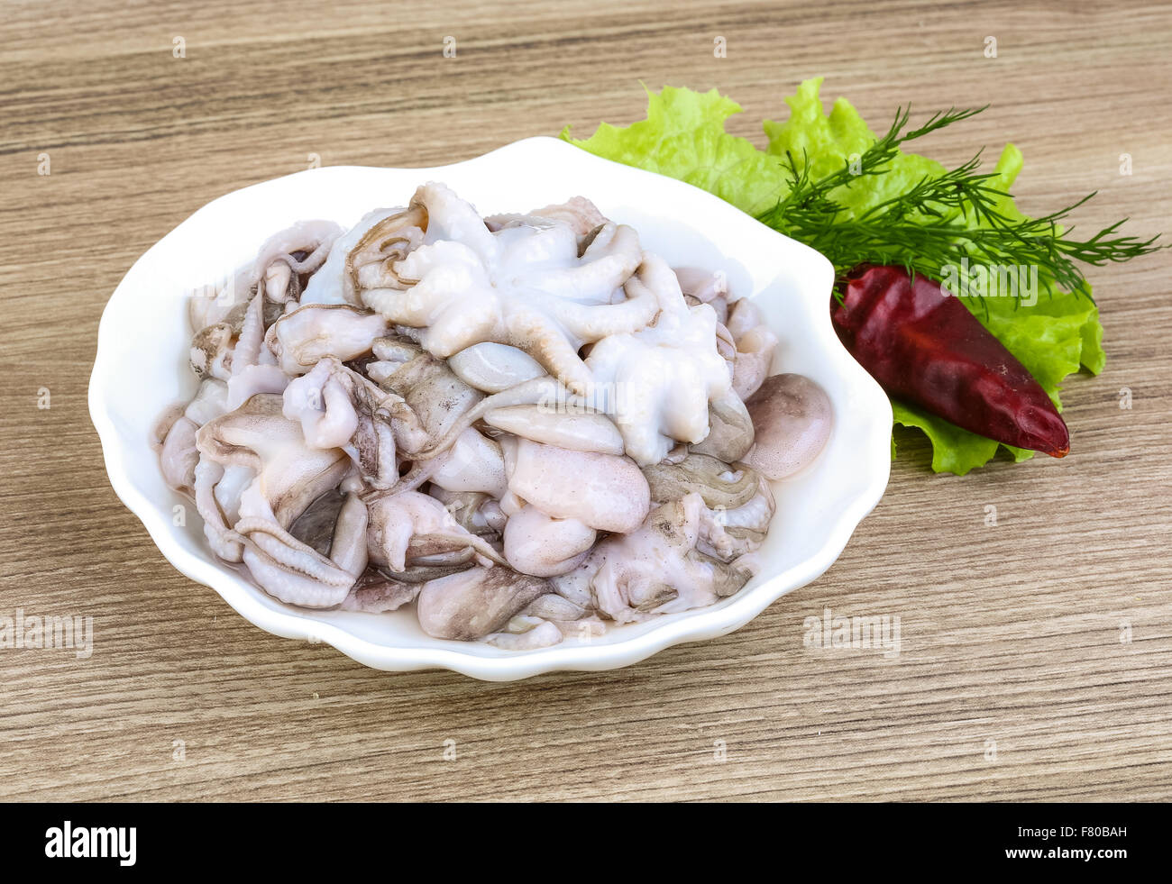 Raw baby octopus in the bowl ready for cooking Stock Photo - Alamy