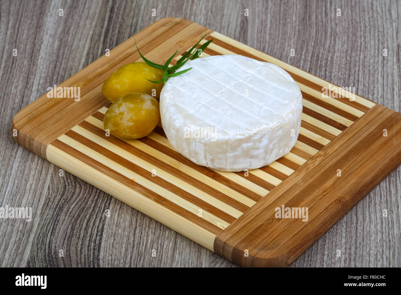 Round Brie cheese with yellow plums and estragon Stock Photo - Alamy